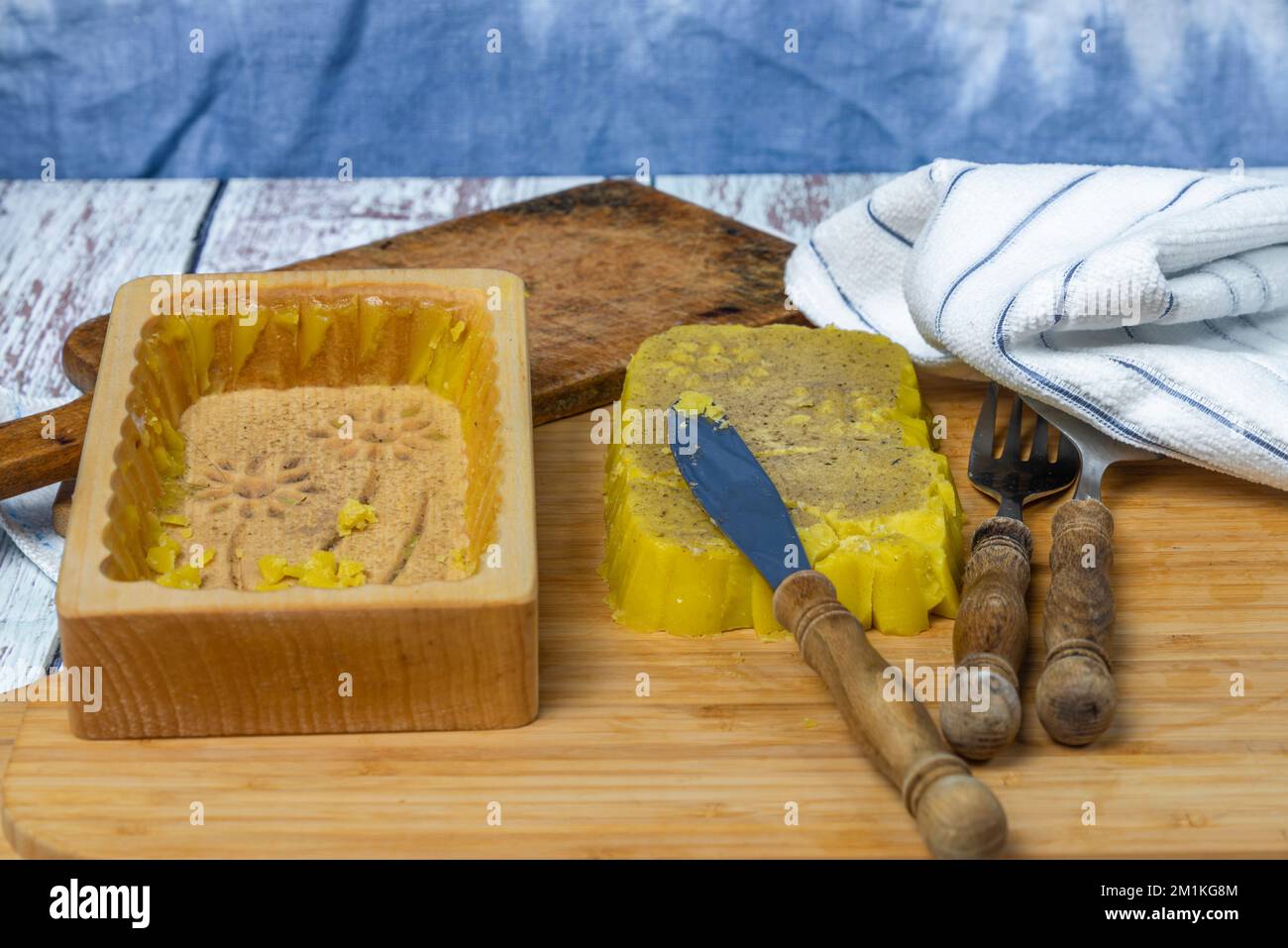 Marijuana butter with wooden mould on blue old table with checker color ...