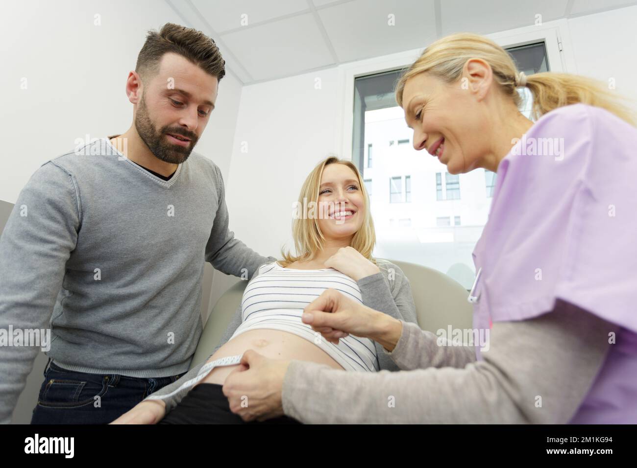 doctor talking to female patient during belly measurment Stock Photo ...