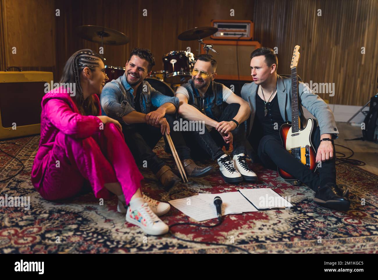 Band members - drummer, vocalist and two guitarists - learning a new ...