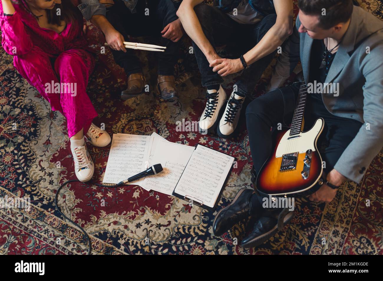 High angle shot of four band members sitting next to note sheets on a ...