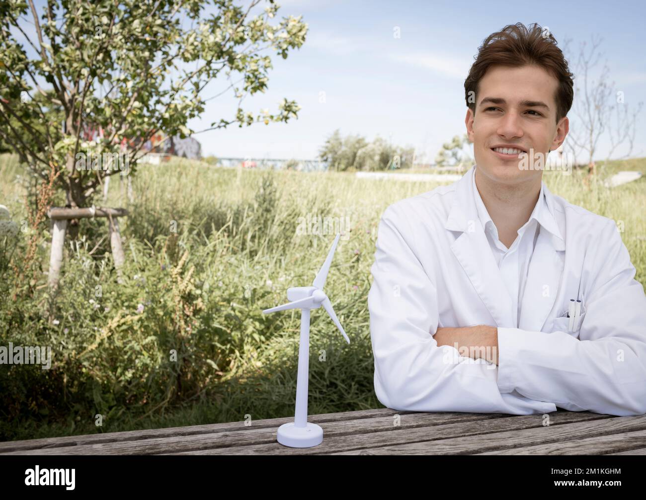 young scientist, student with model of wind turbine standing outside in ...