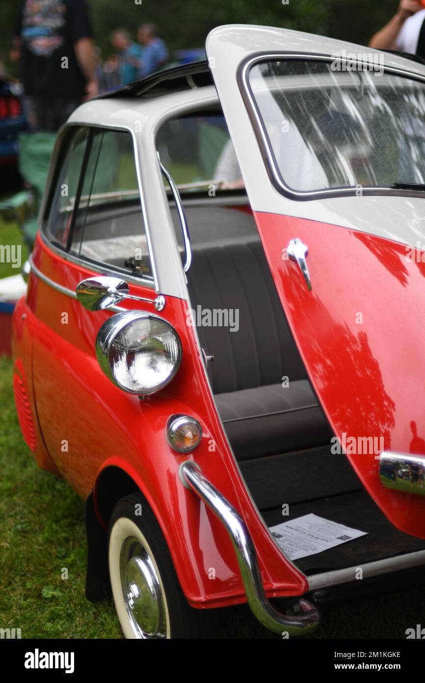 A vertical shot of a red and white vintage Isetta at the Hampshire ...