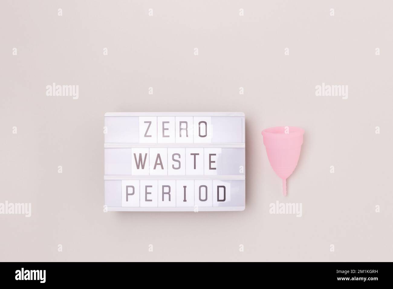 Zero waste period. Lightbox with letters and pink menstrual cup on a ...