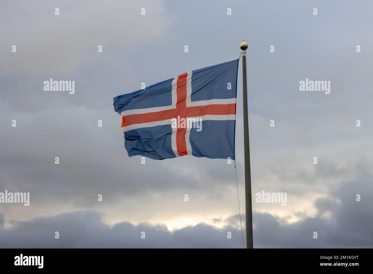 Icelandic flag blowing in the wind outdoors. Early evening cloudy sky ...