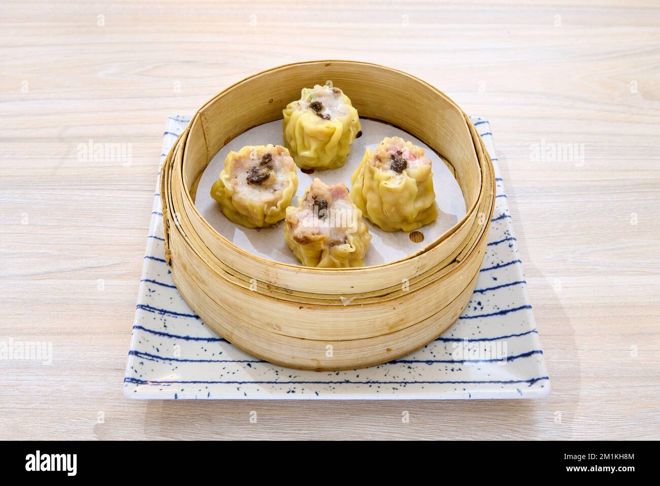 A closeup of delicious Chinese shumai dumplings on a xiaolong bamboo ...