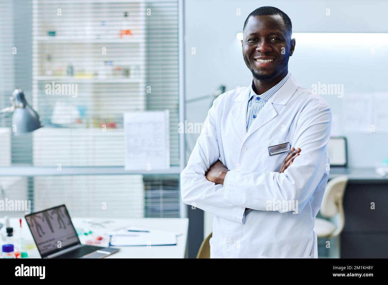 Waist up portrait of smiling black man standing in medical laboratory ...