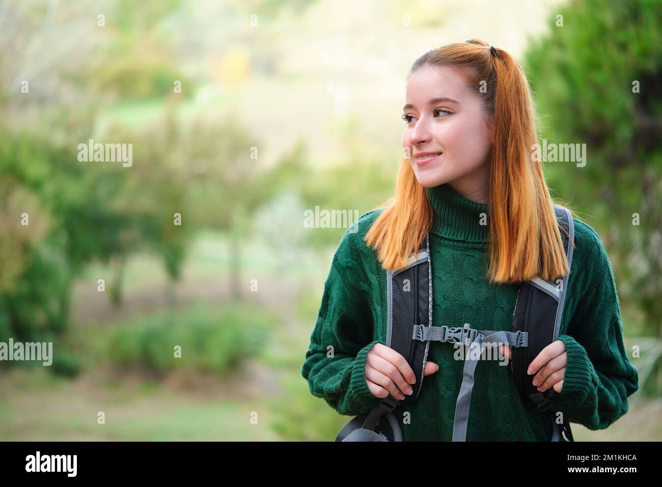 Smiley hiker redhead young woman walking in the mountain wearing a ...