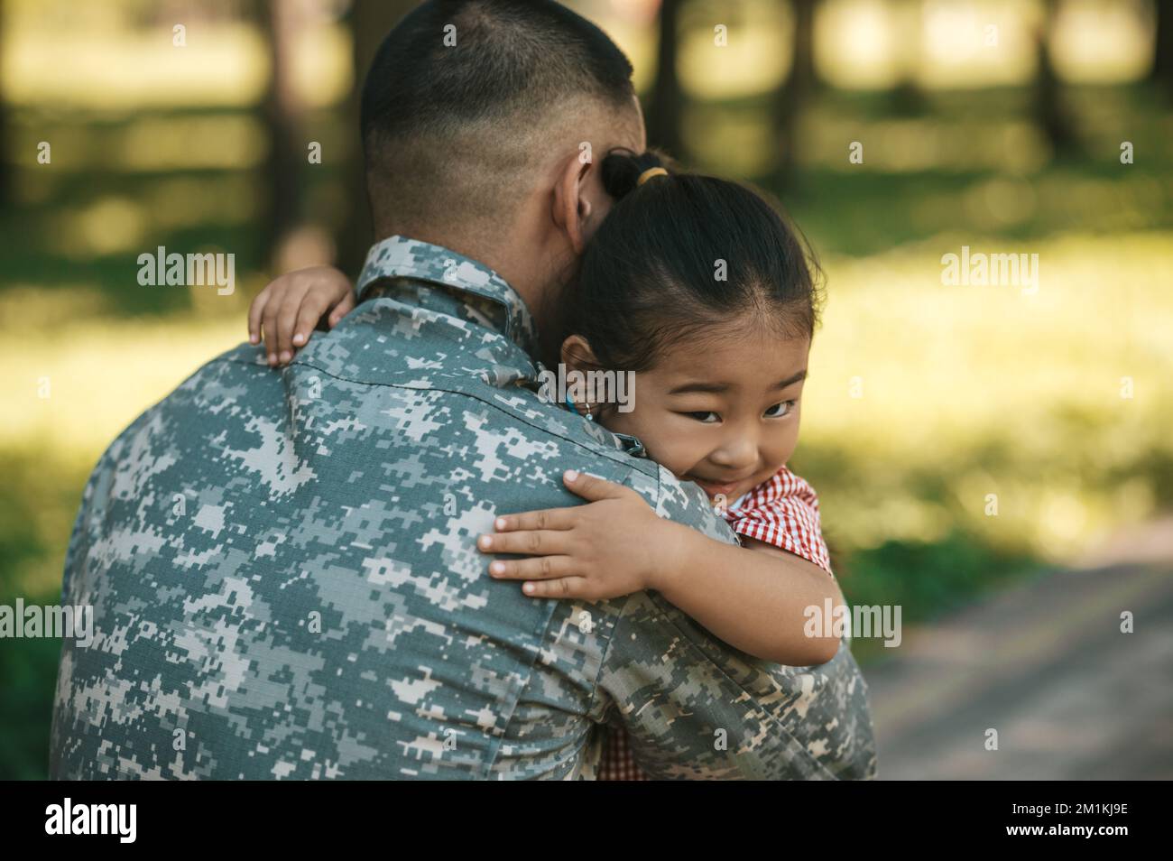 Little girl looking happy while hugging her dad after long parting ...