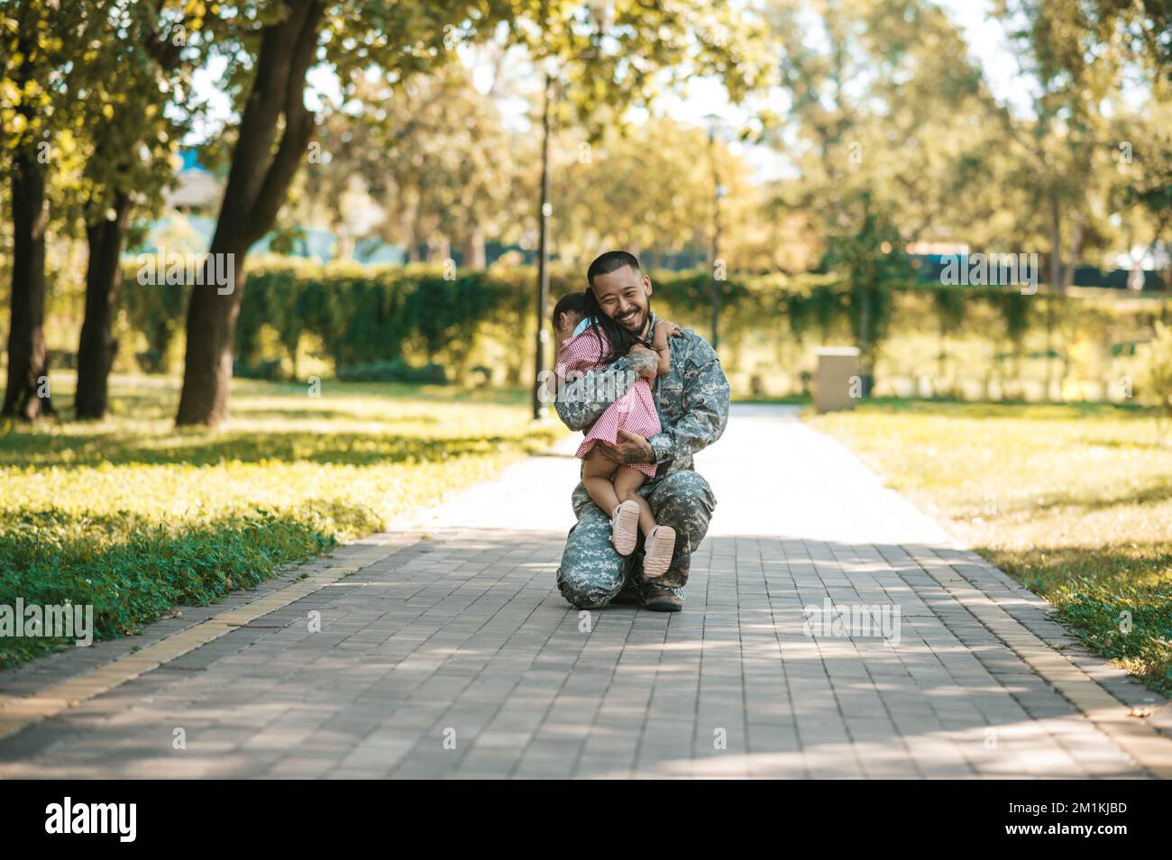 Little girl looking happy while hugging her dad after long parting ...
