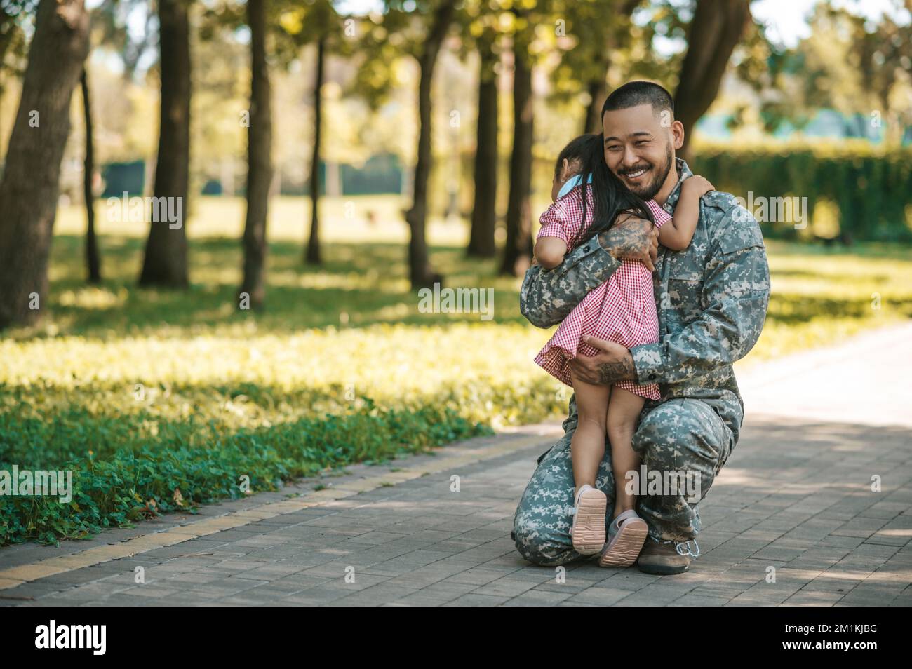Little girl looking happy while hugging her dad after long parting ...