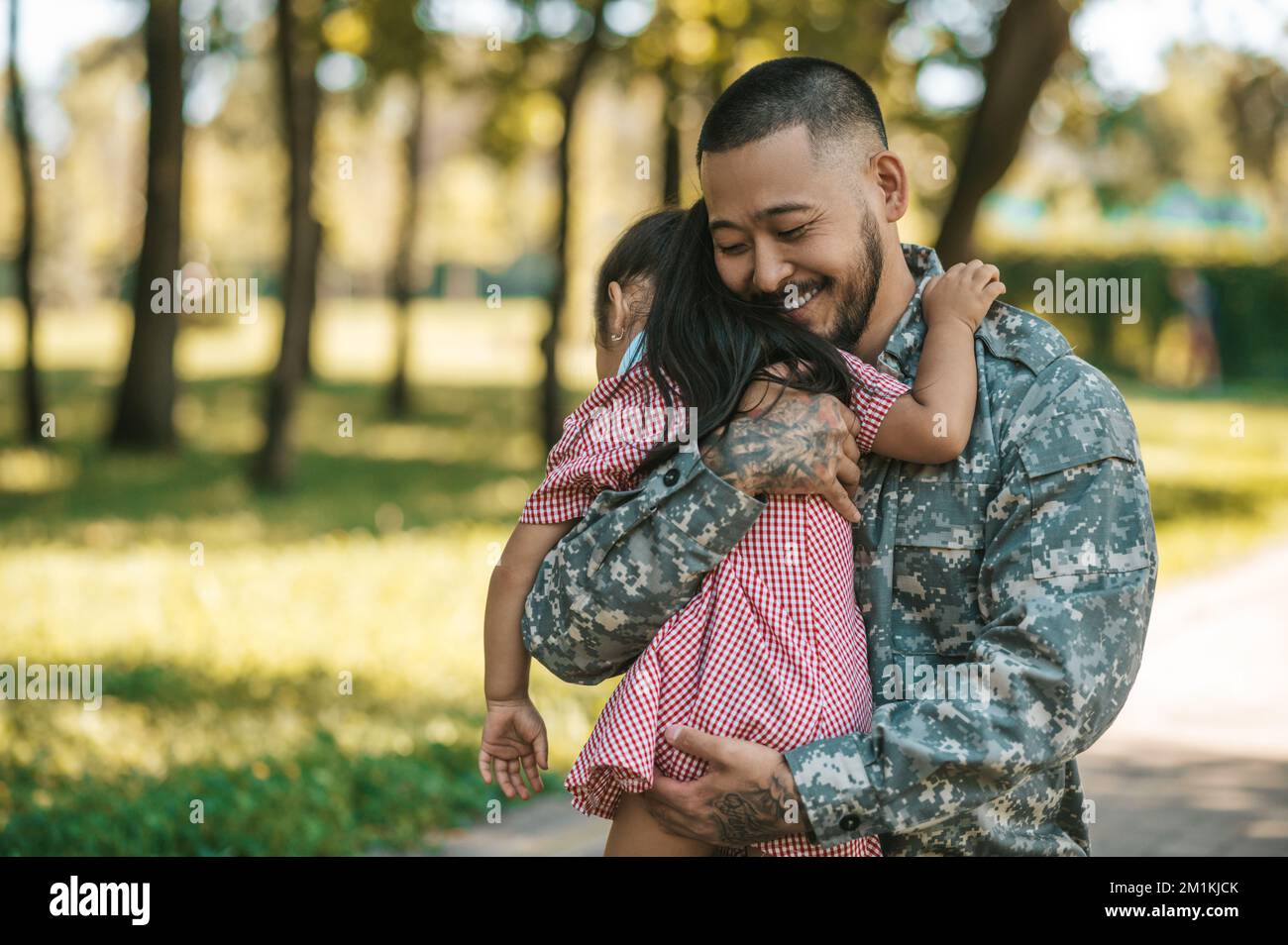 Service man hugging his little daughter and looking happy Stock Photo ...