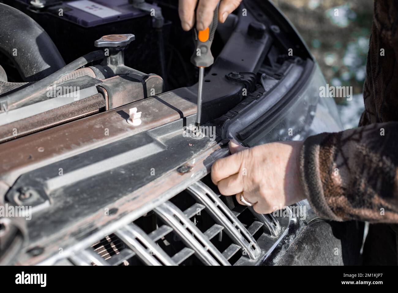 Auto repair. installation of a radiator grille diffuser on a car Stock ...