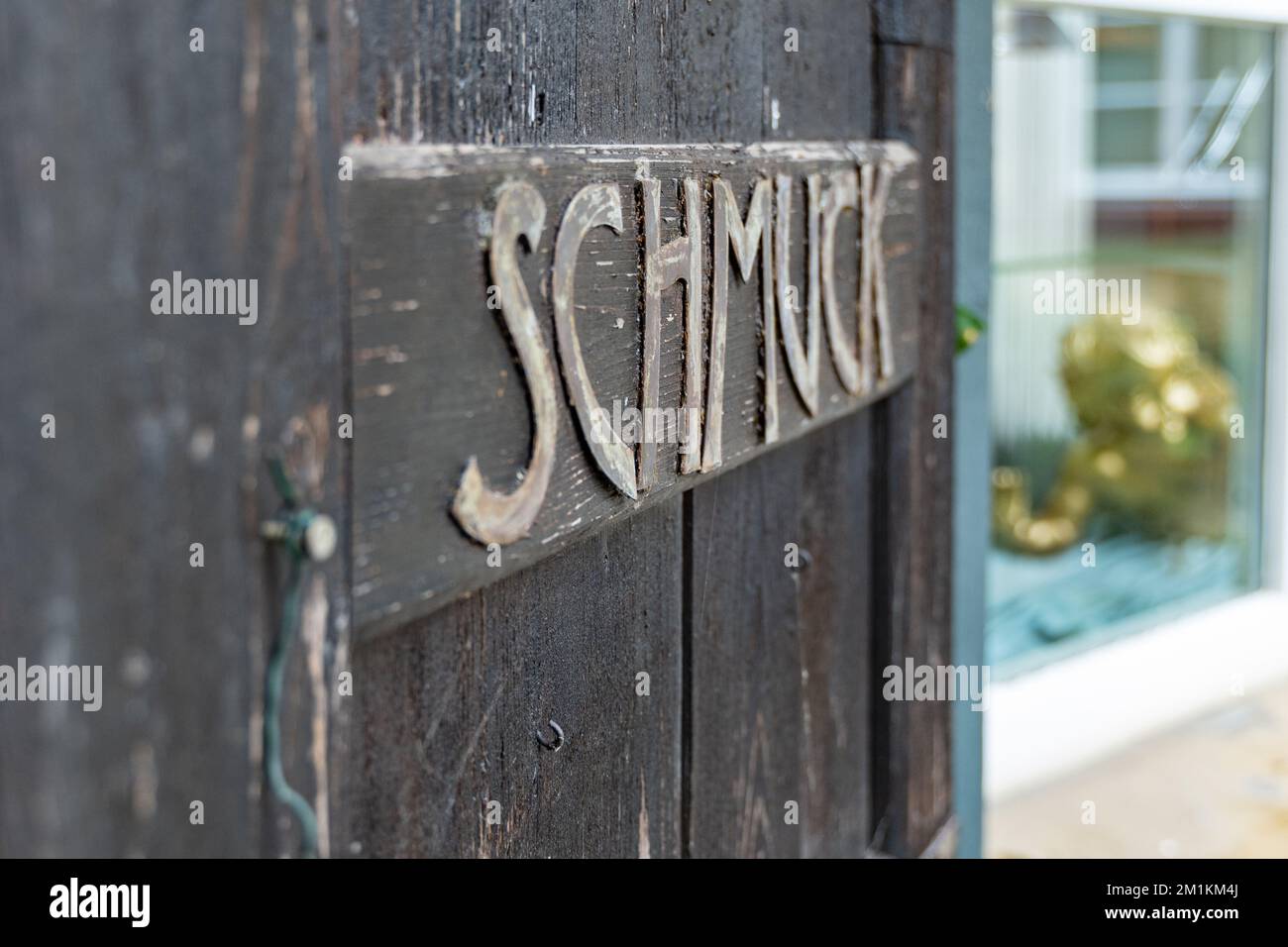A side shot of schmuck text on gray old wooden dorr with blur ...
