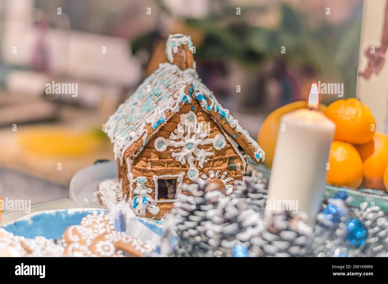 burning candle on christmas decoration and decorated gingerbread house ...