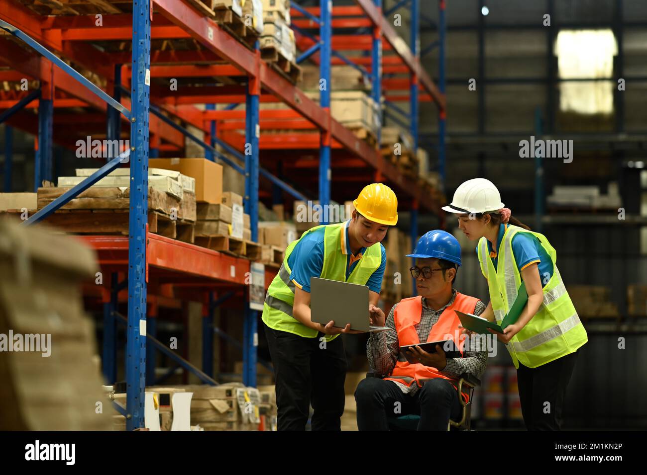 Middle age male manager and young workers using laptop with inventory ...