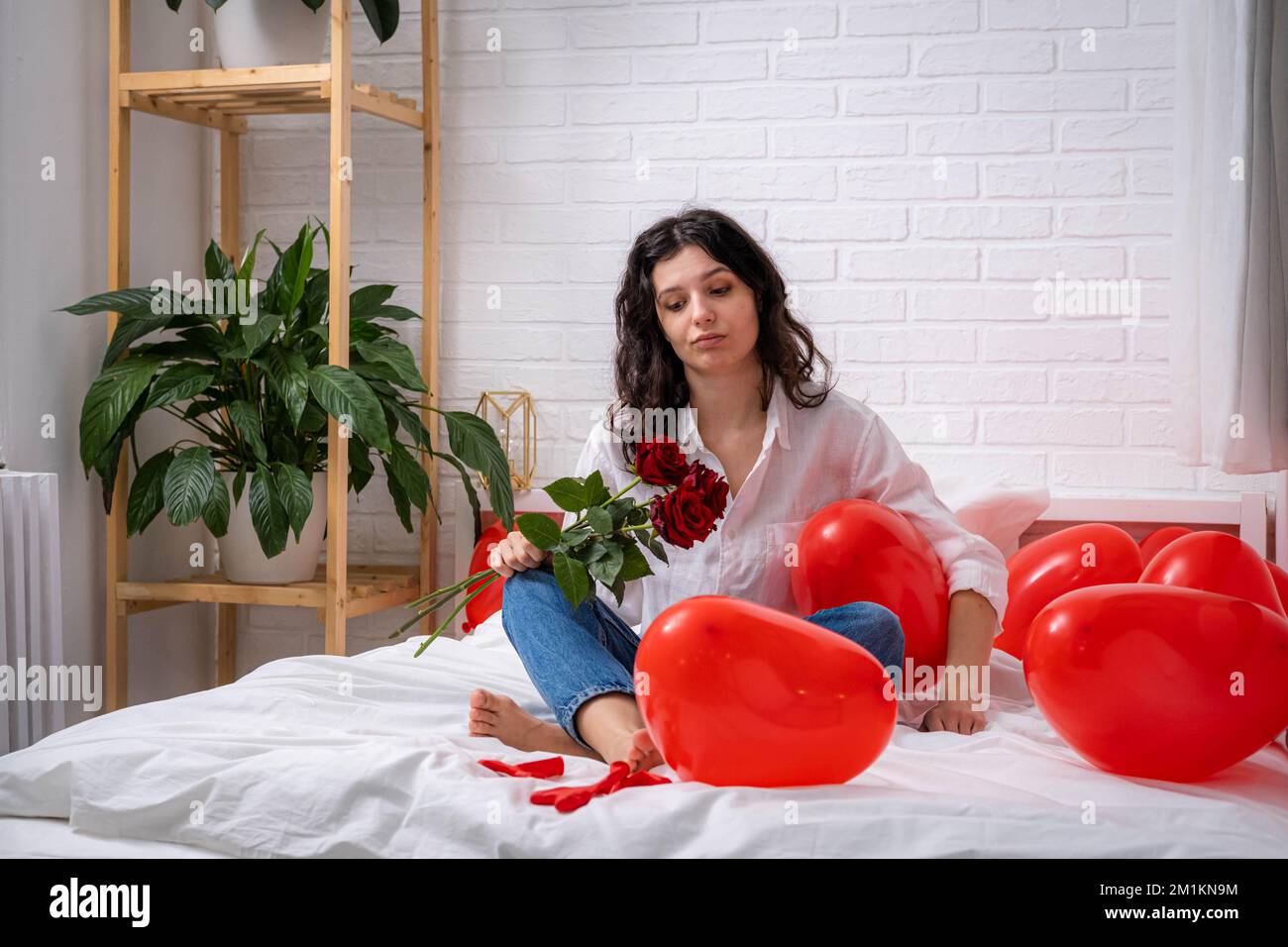 displeased upset girl with bouquet of rose flowers on bed red heart ...