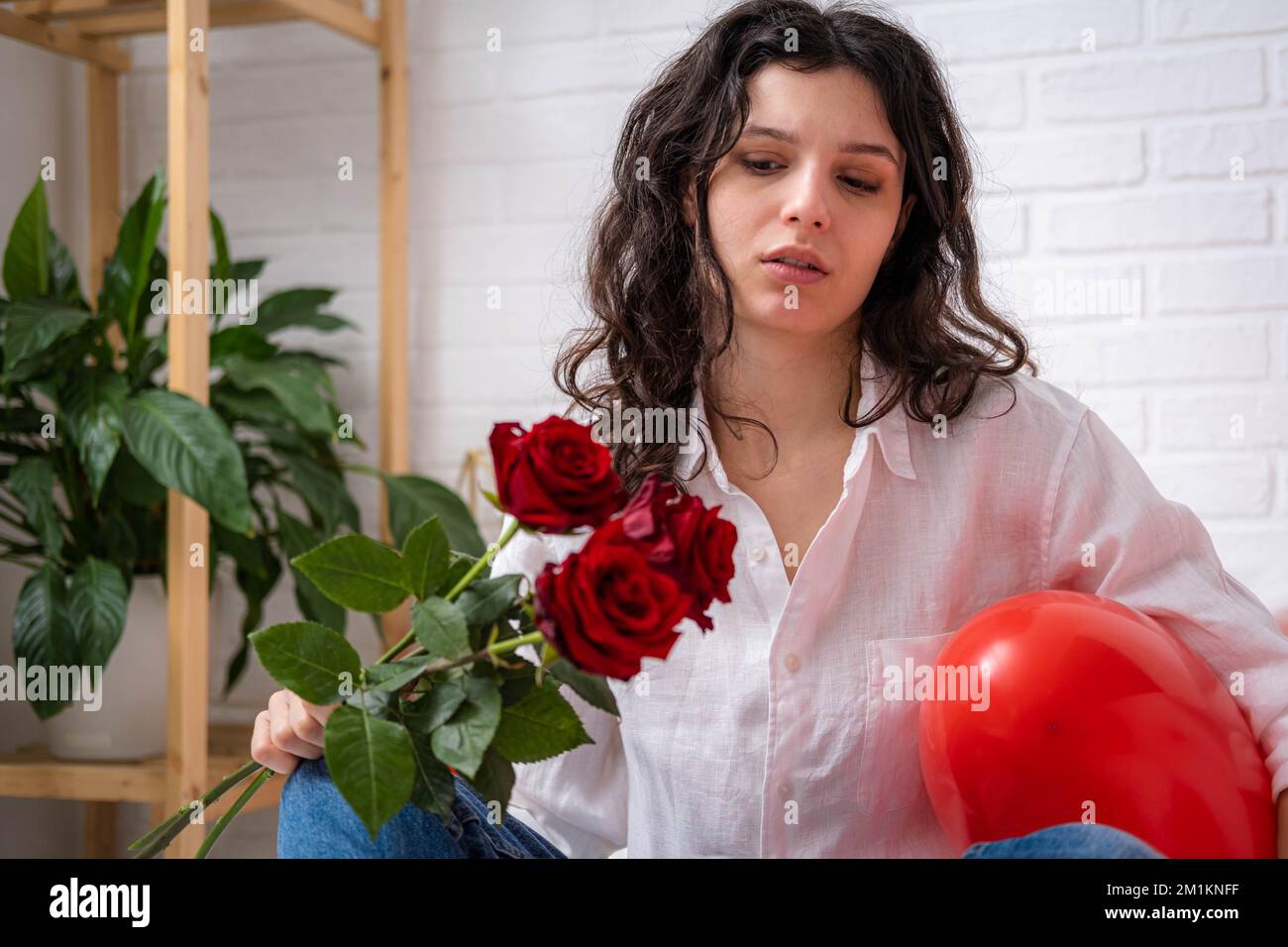 displeased upset girl with bouquet of rose flowers on bed red heart ...