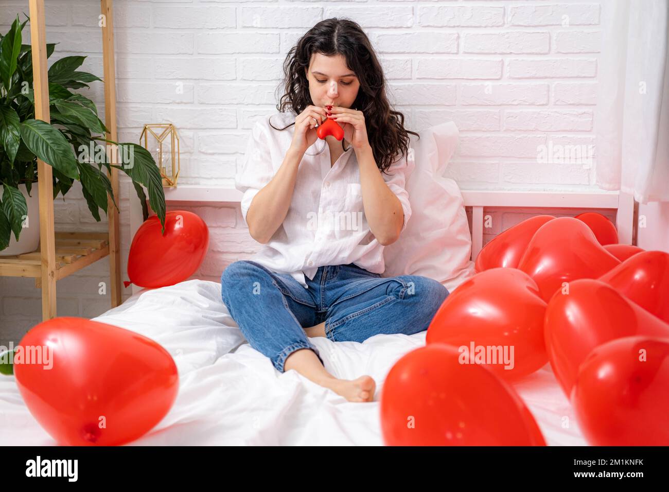 Girl is blowing air balloon at home Handsome brunette girl inflating ...