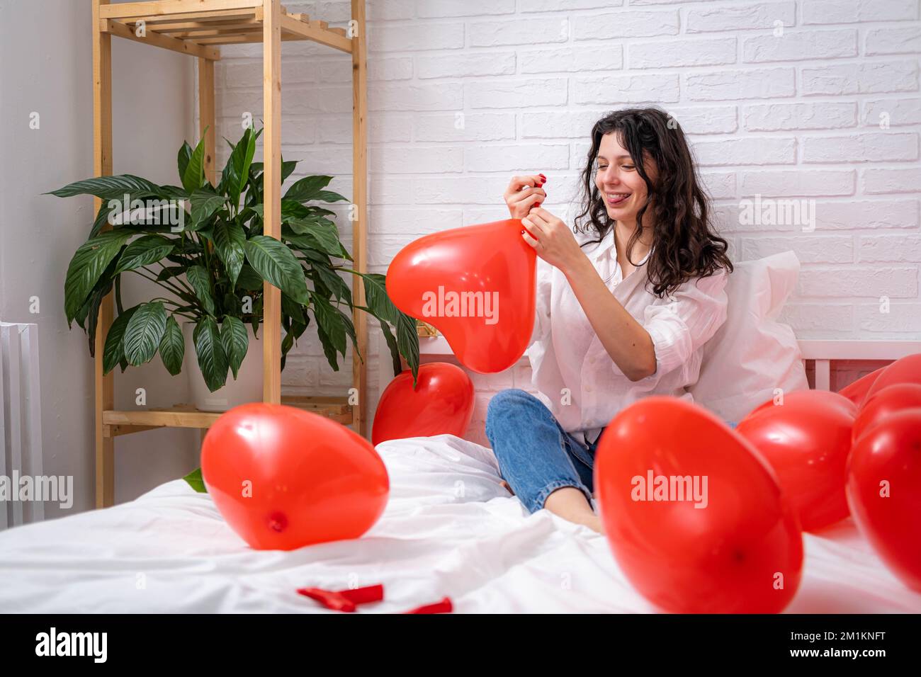 Girl is blowing air balloon at home Handsome brunette girl inflating ...