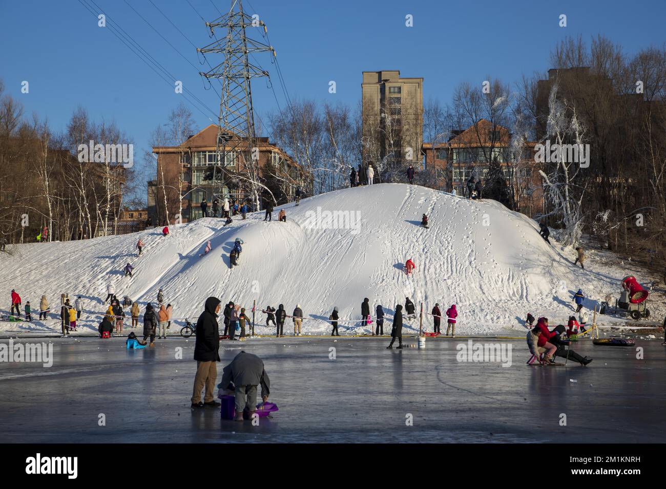Parents and children play with the snow and ice in Jiangbin Park, Jilin ...