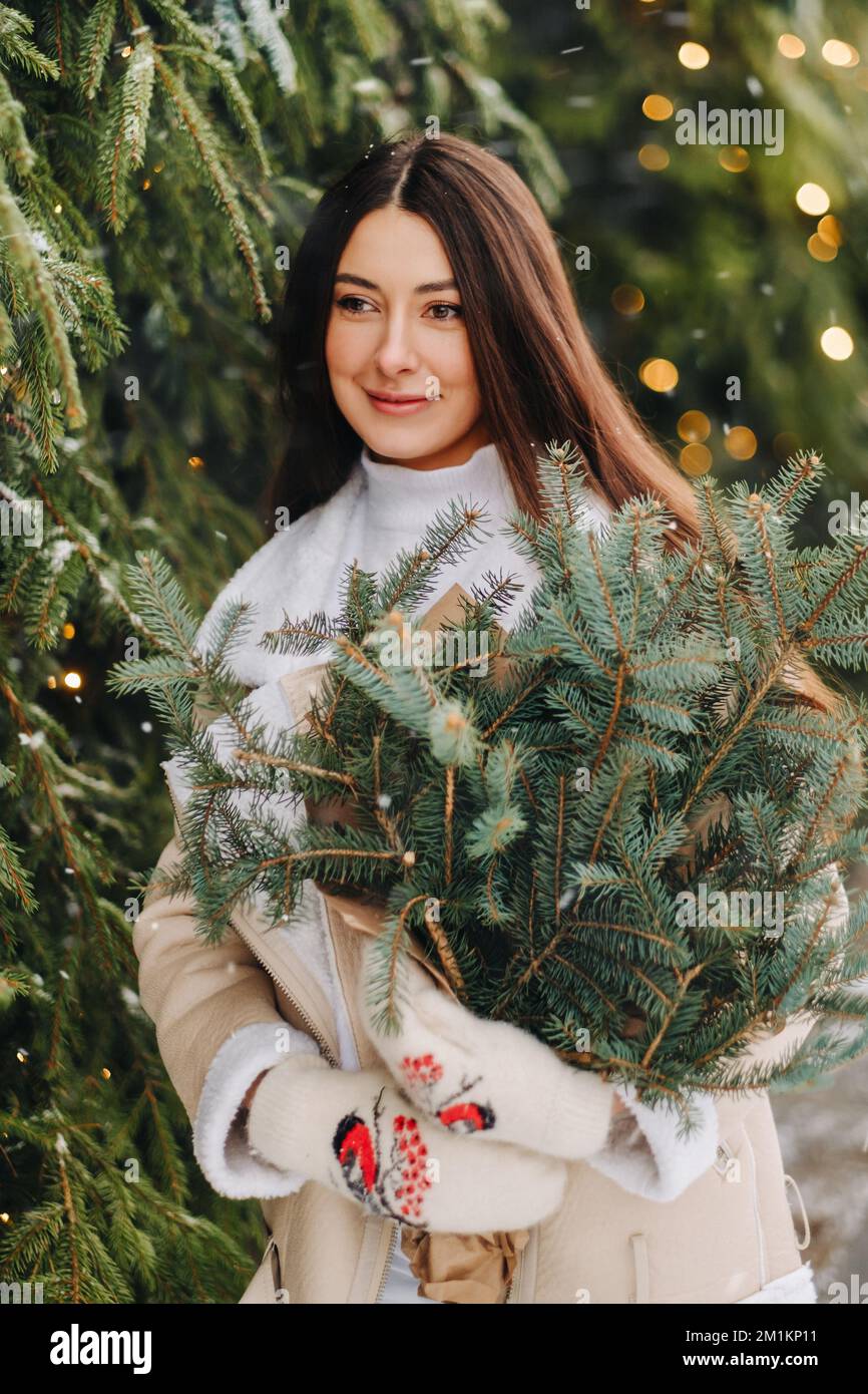 A girl with long hair in winter on the street with a bouquet of fresh ...