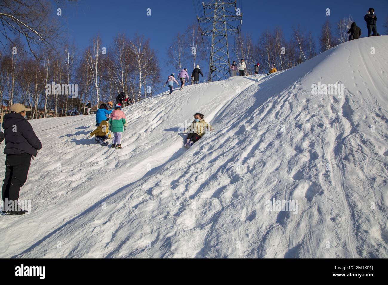Parents and children play with the snow and ice in Jiangbin Park, Jilin ...
