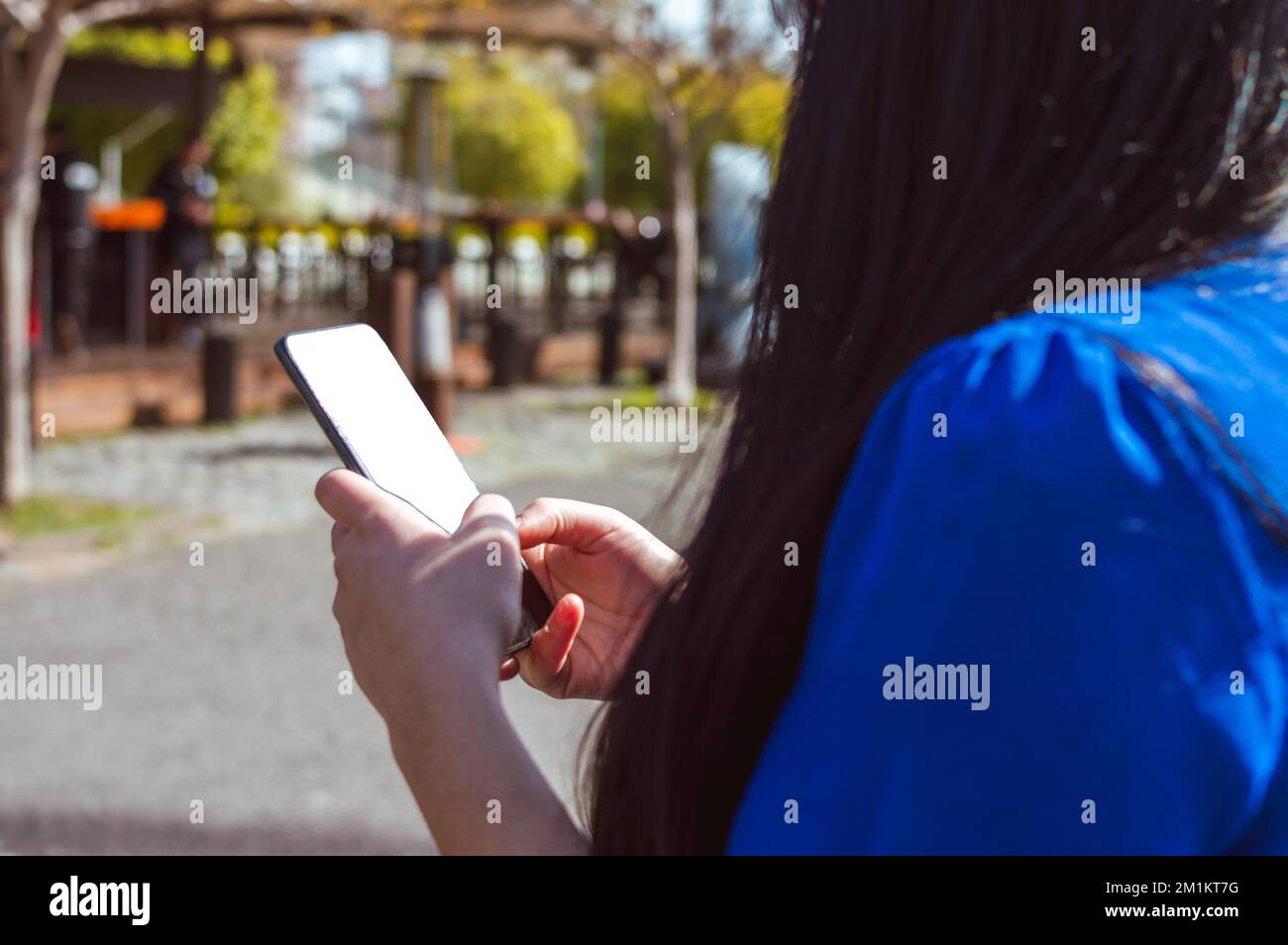 rear view of unrecognizable long haired woman in blue clothes standing ...