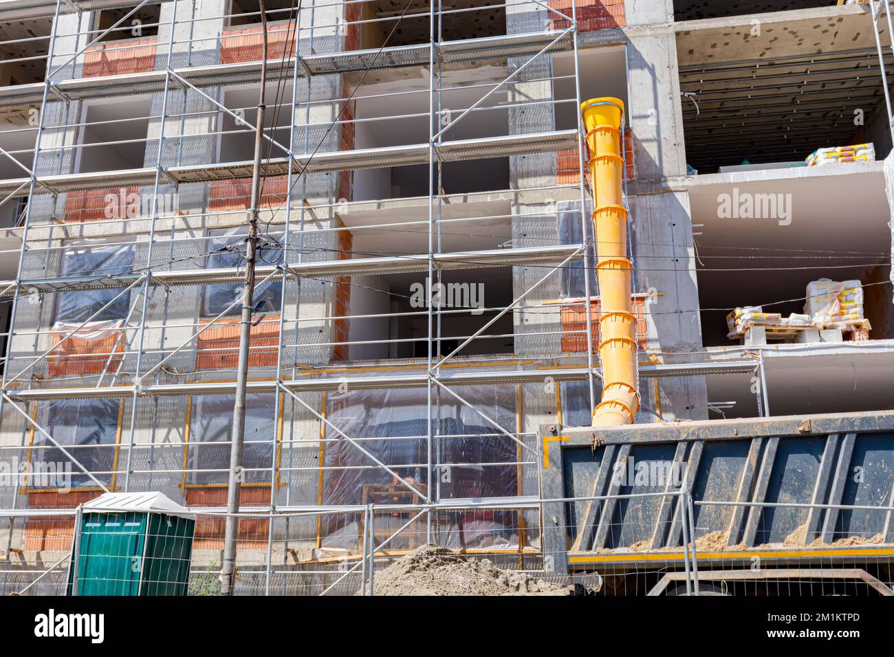 Yellow long plastic tube placed next to building under construction for ...