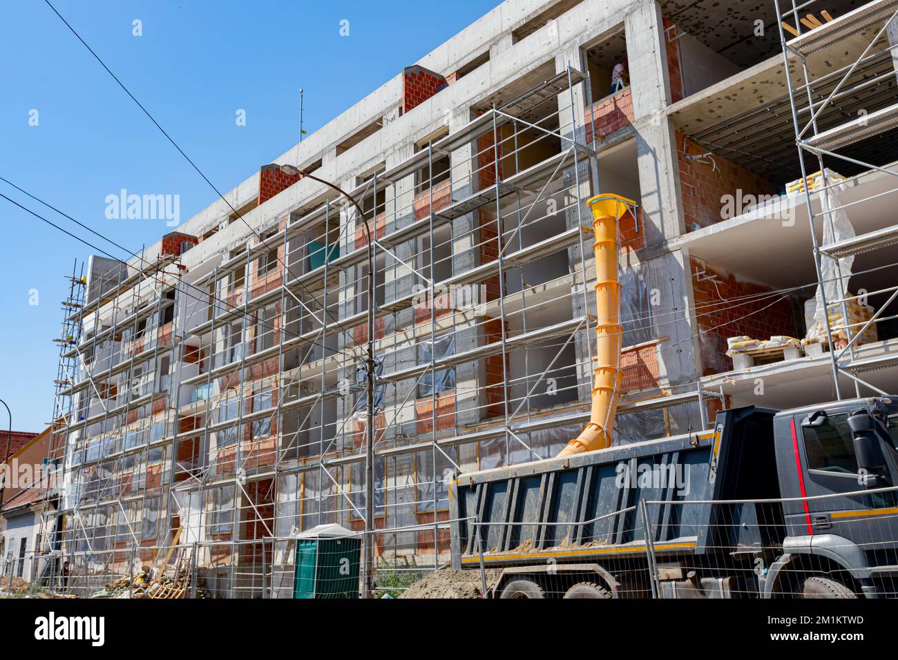 Yellow long plastic tube placed next to building under construction for ...