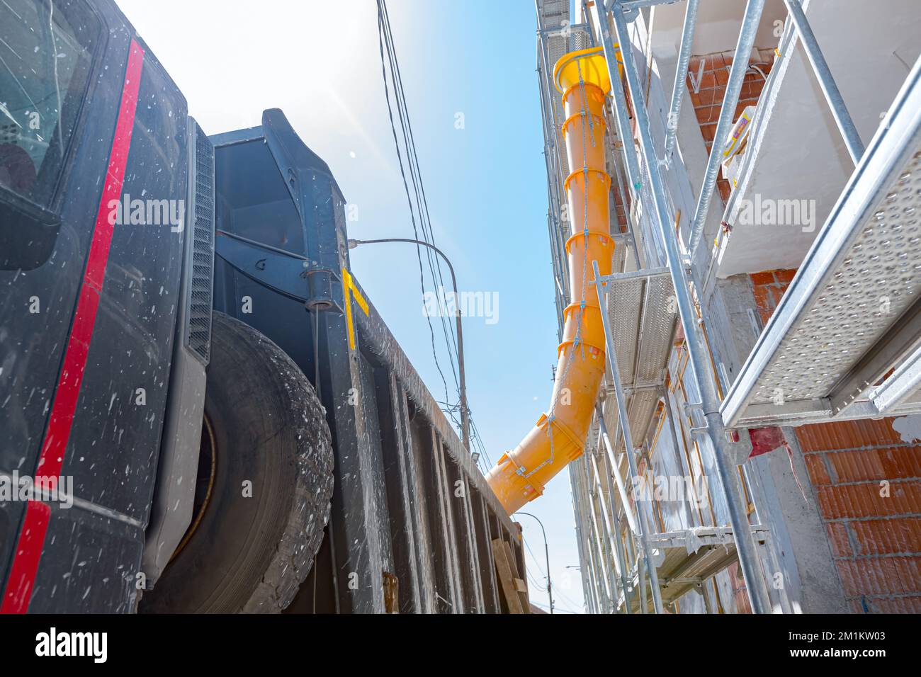 Shot from bellow on yellow long plastic tube placed next to building ...