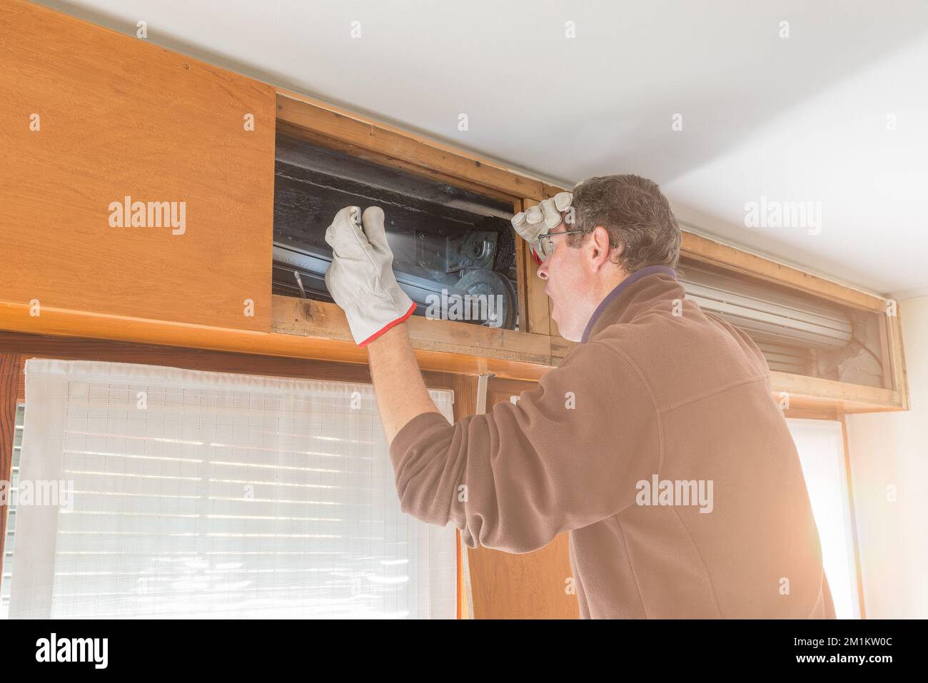 Broken house roller shutter. Man agape and surprised by the damage who ...