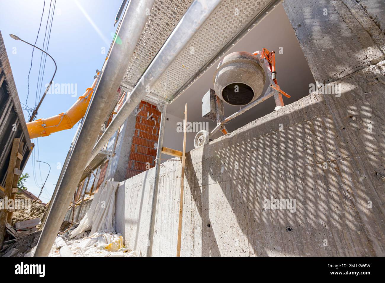 Shot from bellow on yellow long plastic tube placed next to building ...