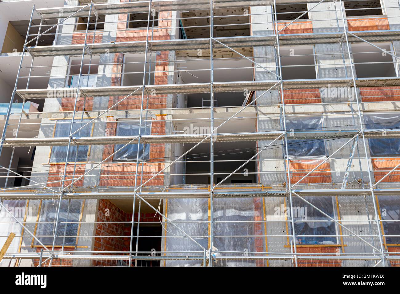 View from below on scaffold placed against unfinished edifice, new ...