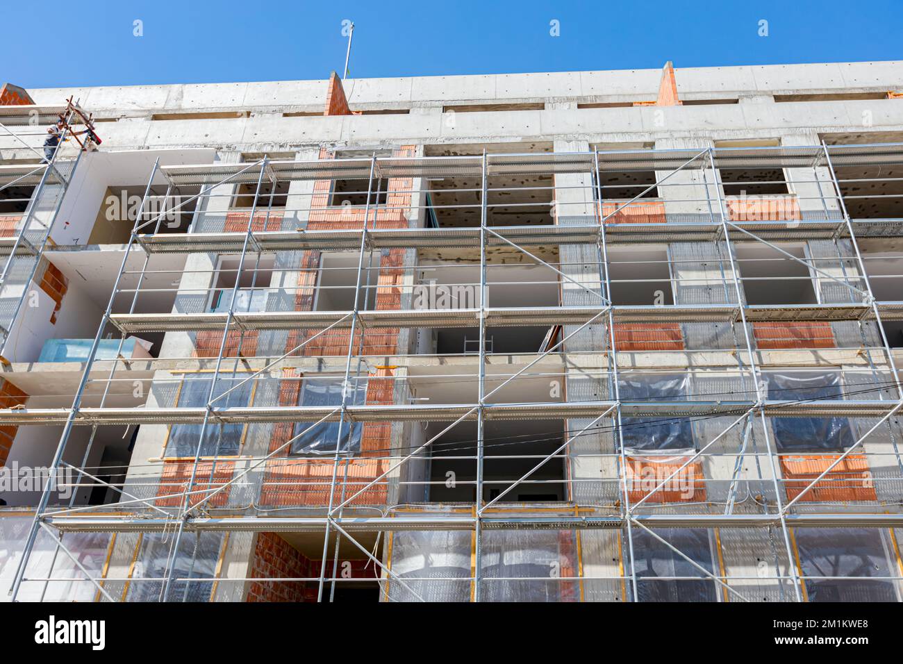 View from below on scaffold placed against unfinished edifice, new ...