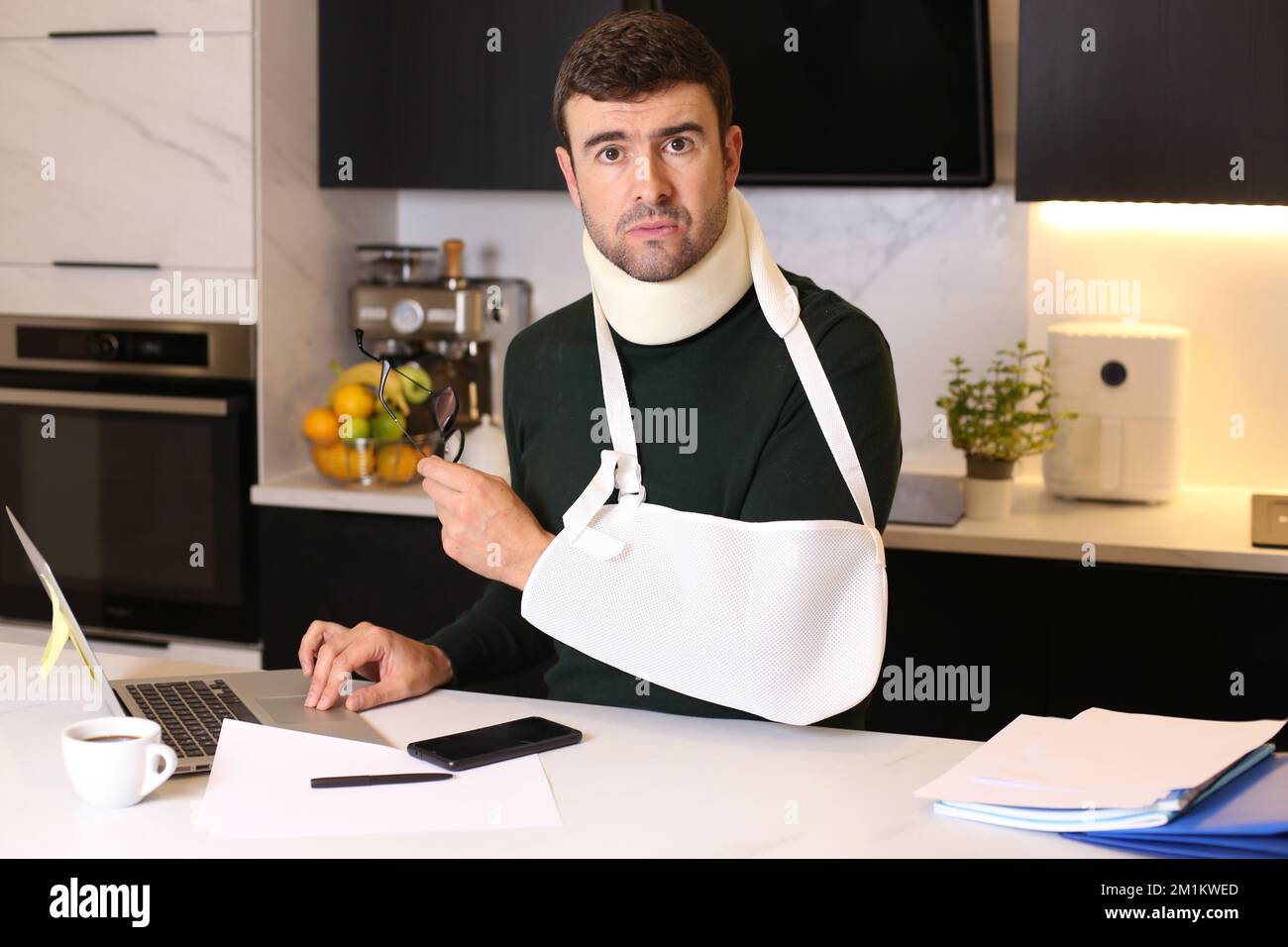 Worker doing home office after an accident Stock Photo - Alamy