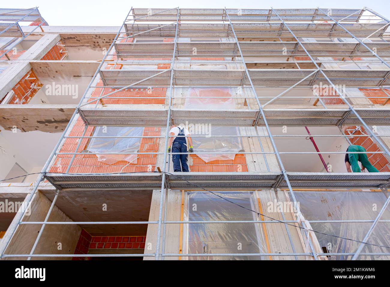 View from below on scaffold placed against unfinished edifice, new ...