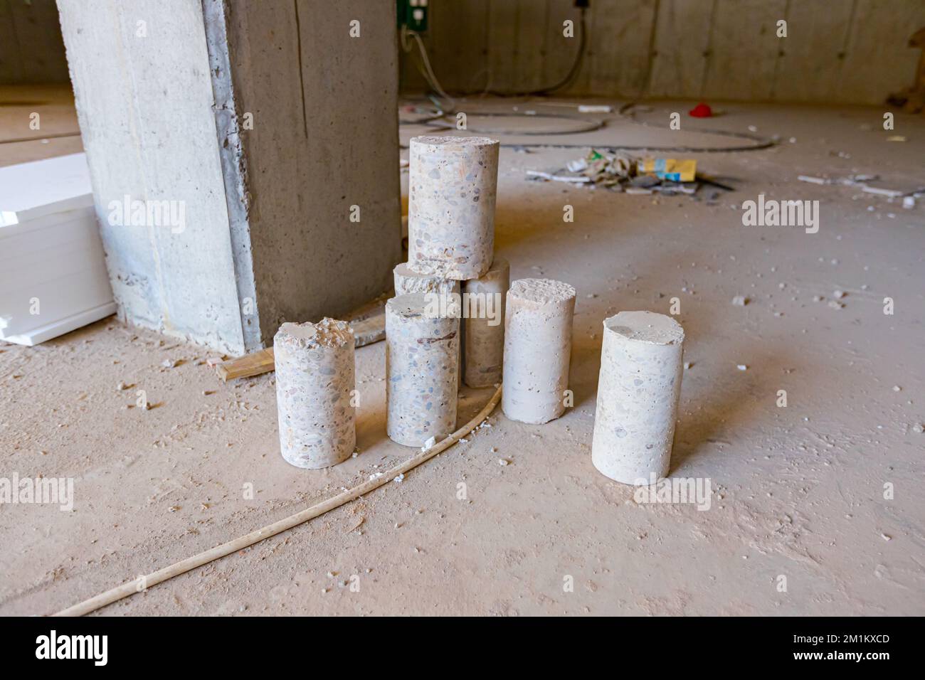 A few concrete cylindrical pillars placed on the floor of building ...