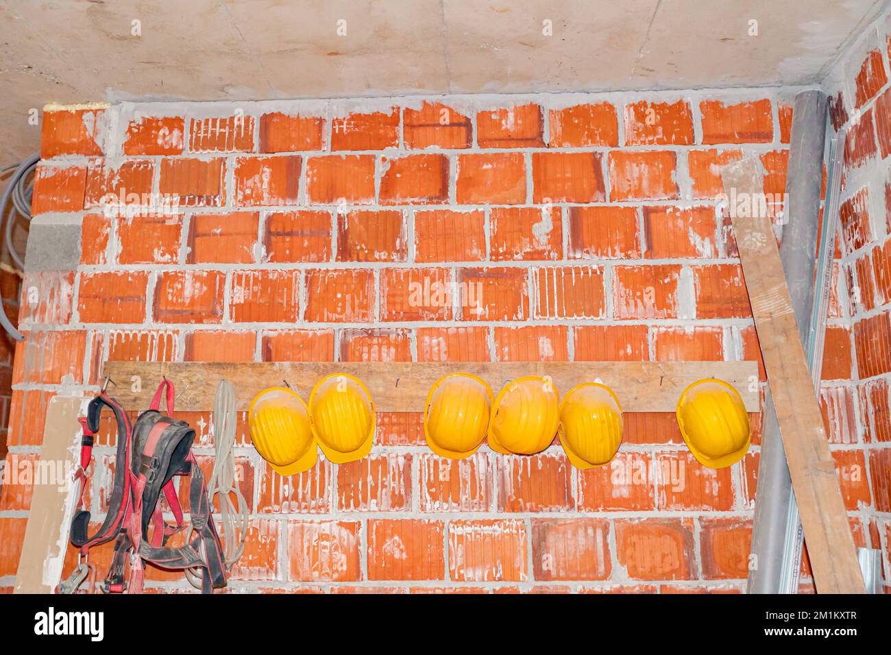 Workers' industrial work equipment, yellow helmets and safety belts ...