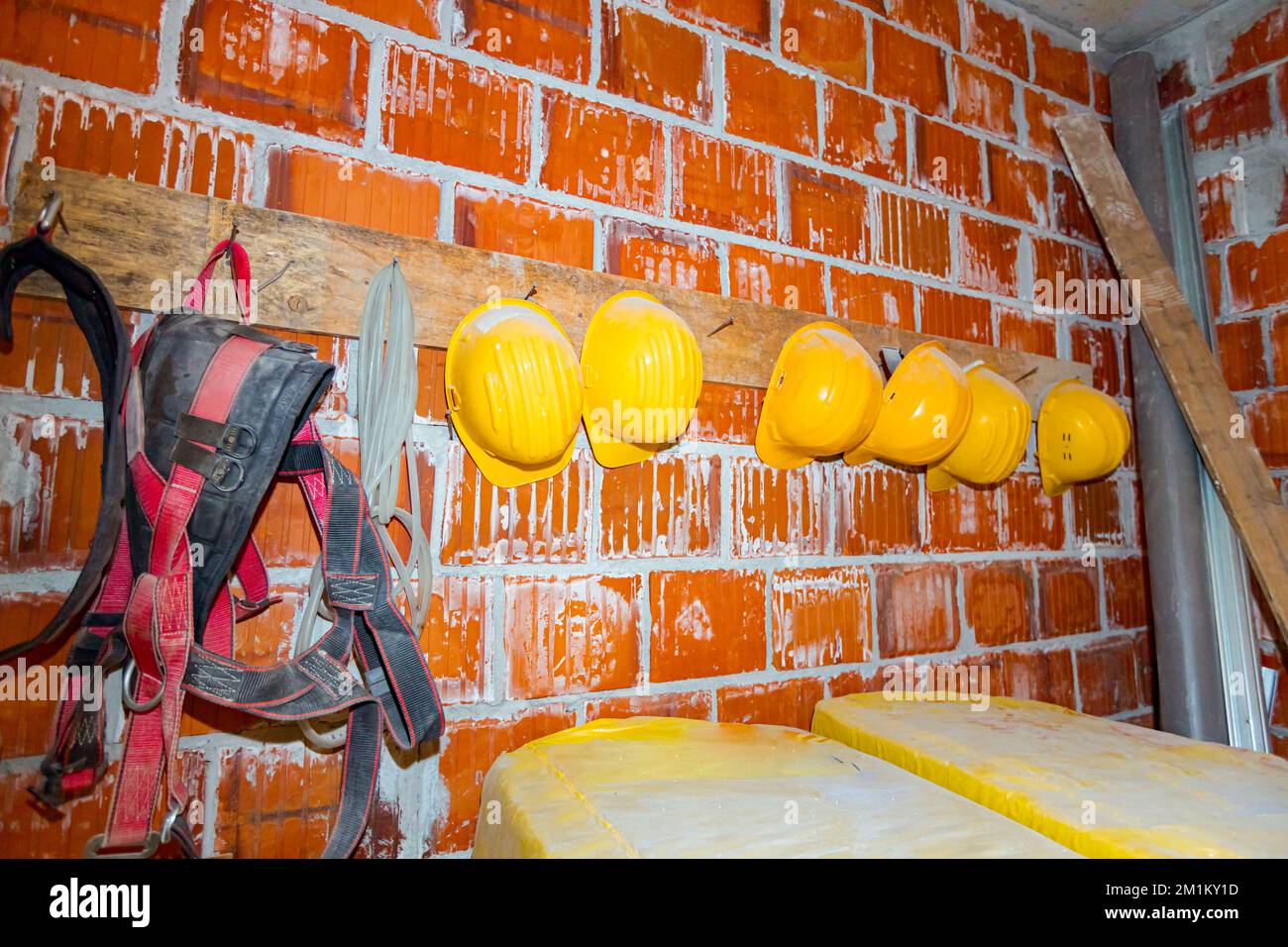 Workers' industrial work equipment, yellow helmets and safety belts ...