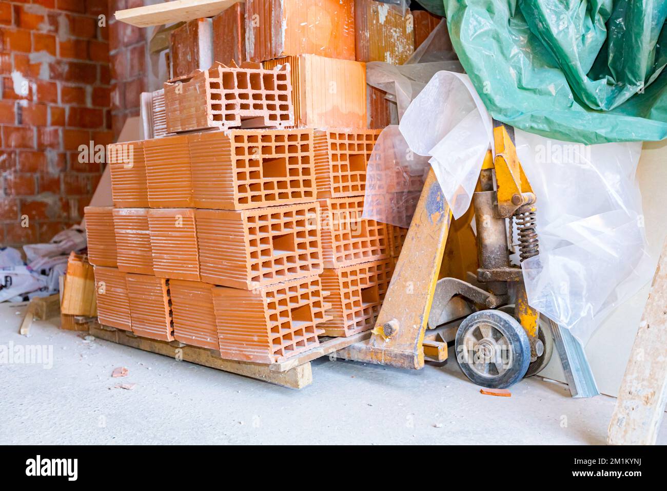 Stacked red blocks at the wooden pallet placed on metal, manually ...