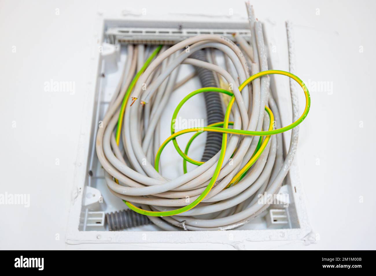 Bundle of various cables hang from a plastic fuse box mounted on the ...