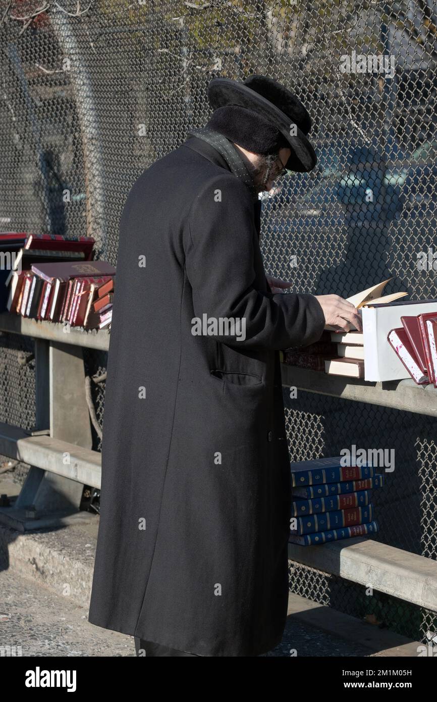 An orthodox Jewish man with long peyot shops at a religious book sale ...