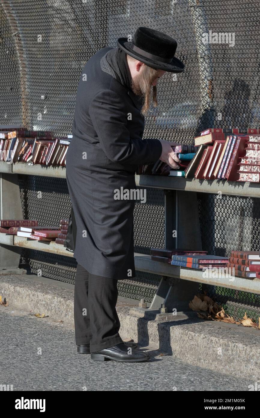 An orthodox Jewish man with long peyot shops at a religious book sale ...
