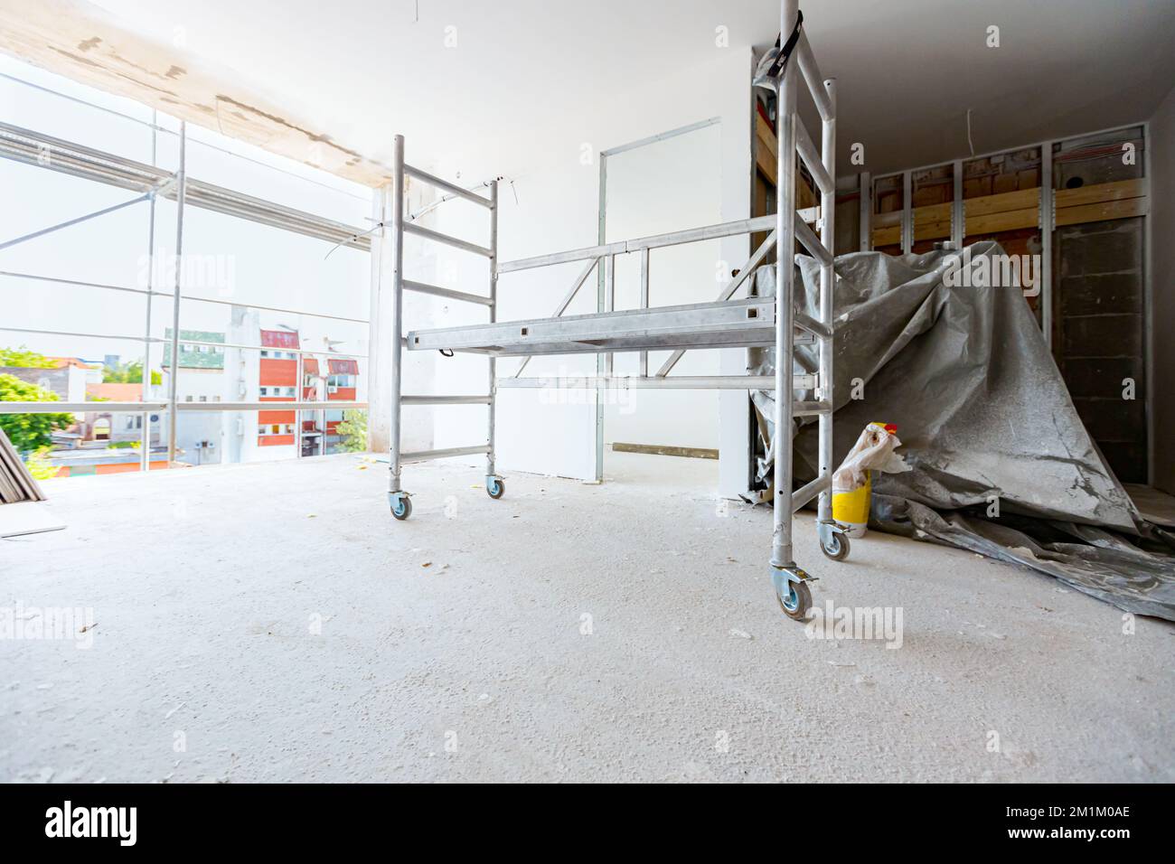 Mobile metal scaffolding with small wheels and protective helmet on it ...