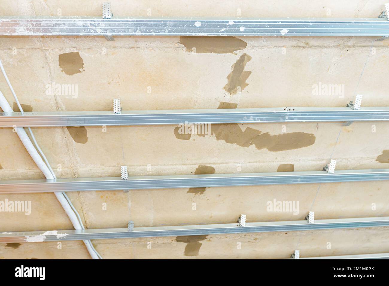Frame of new metal profiles for drywalls arranged on plaster ceiling ...