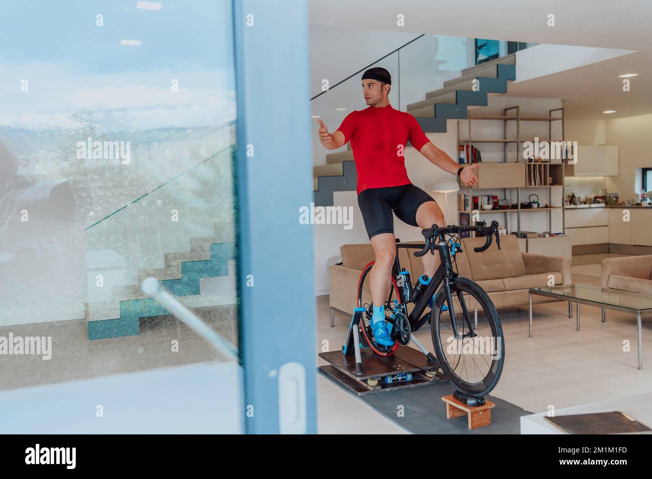 A man riding a triathlon bike on a machine simulation in a modern ...