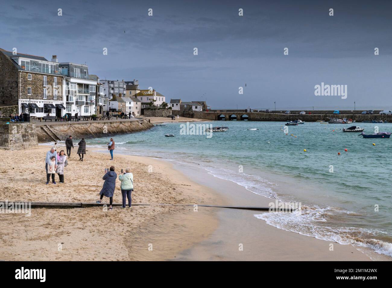 UK weather. Visitors on the beach on a rainy chilly miserable day in ...