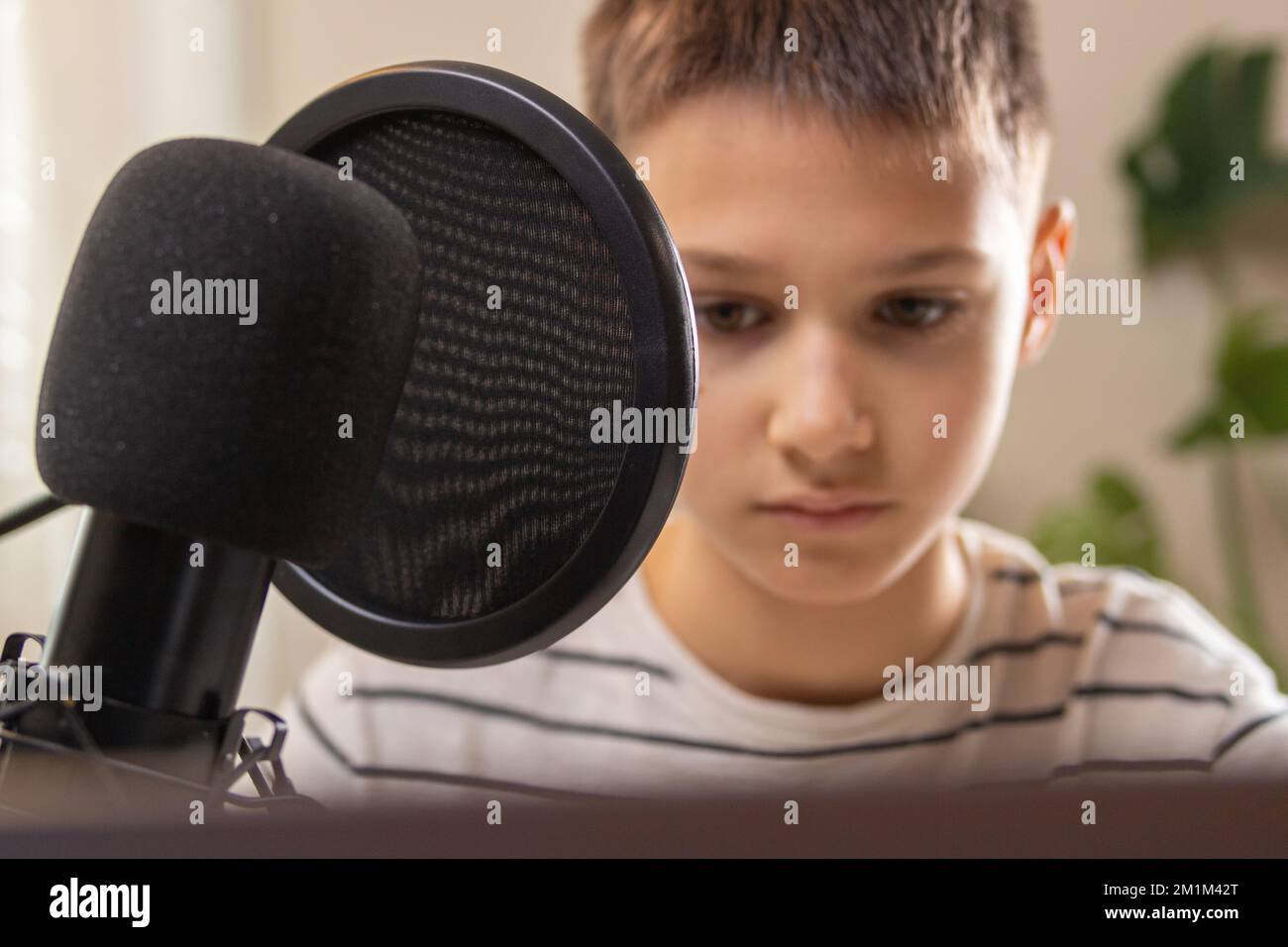 Kid talking into microphone. Techology, online learning, remote ...