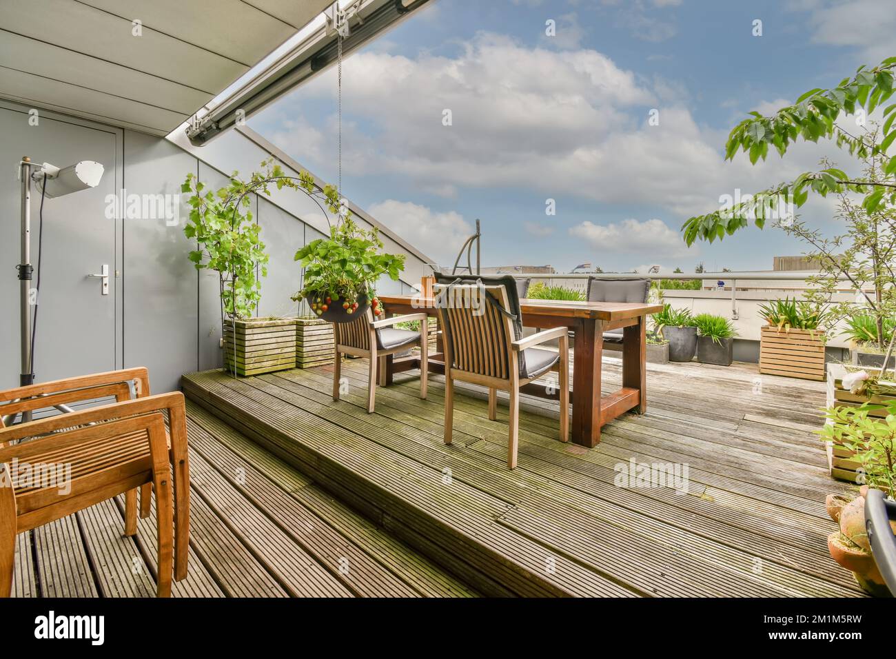 a balcony with wooden decking and plants on the table, in front of an ...