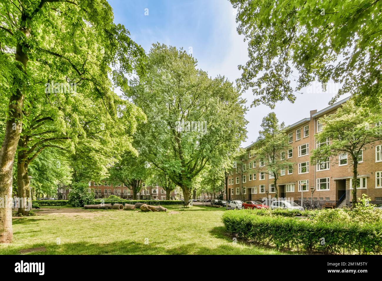 an apartment complex with trees in the yard and lawns on both sides ...